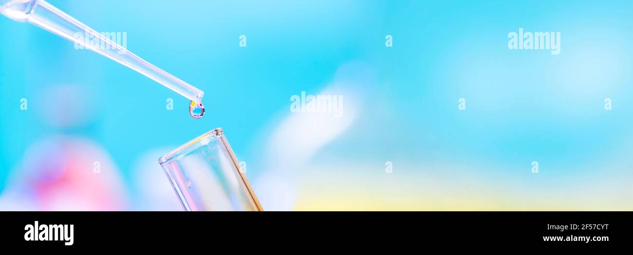 Chemical test tube and pipette with a drop of colorless liquid close up ...