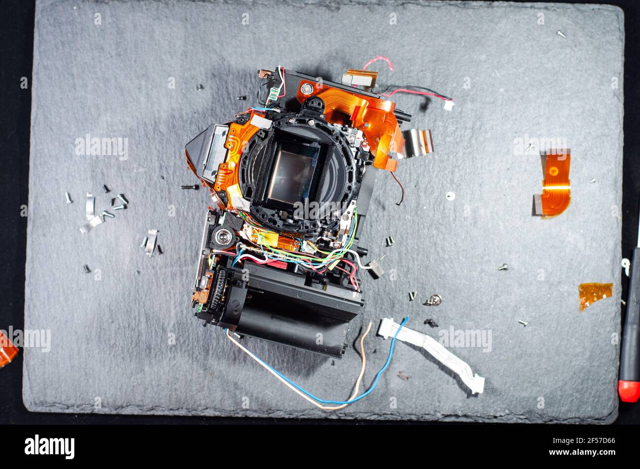 The disassembled camera lies on the subject table in the repair service ...