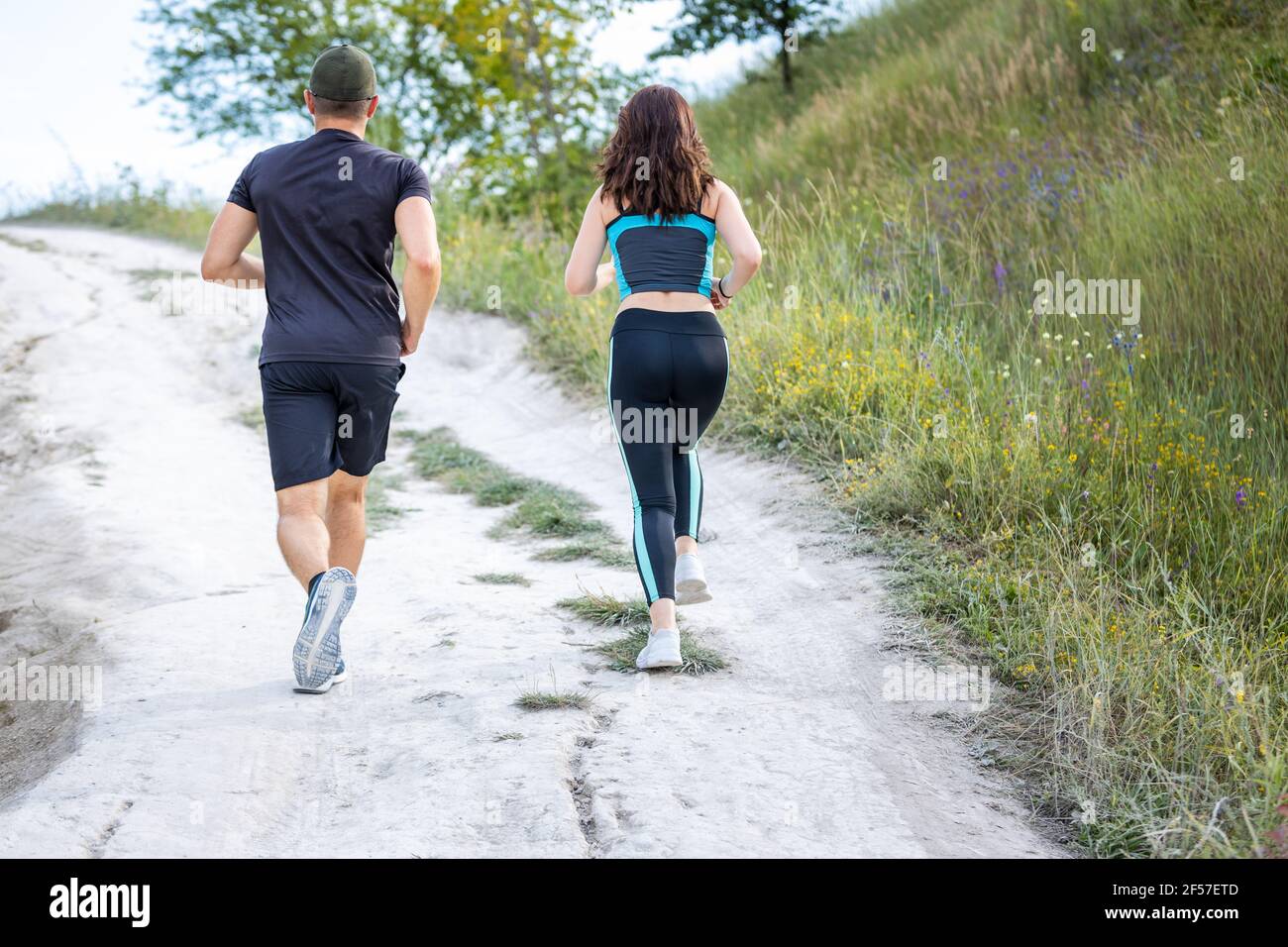 Back view of couple or friends running outdoors Stock Photo - Alamy