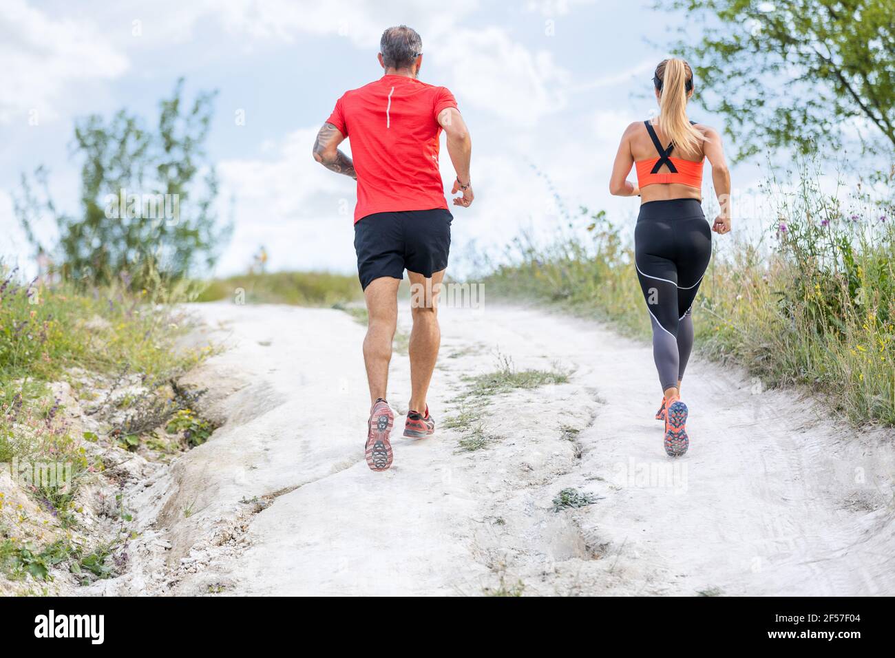 Back view of couple or friends running outdoors Stock Photo - Alamy