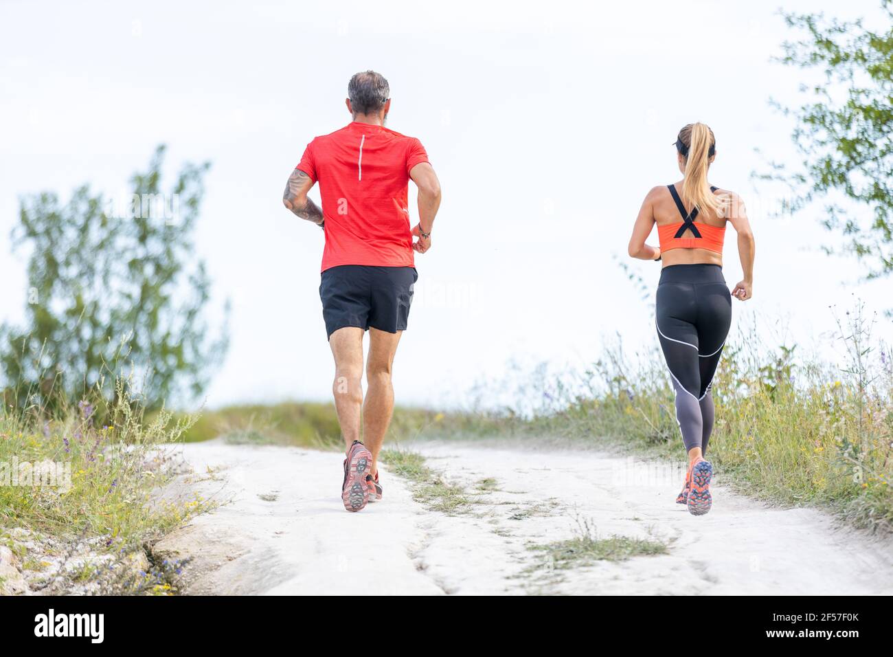 Back view of couple or friends running outdoors Stock Photo - Alamy