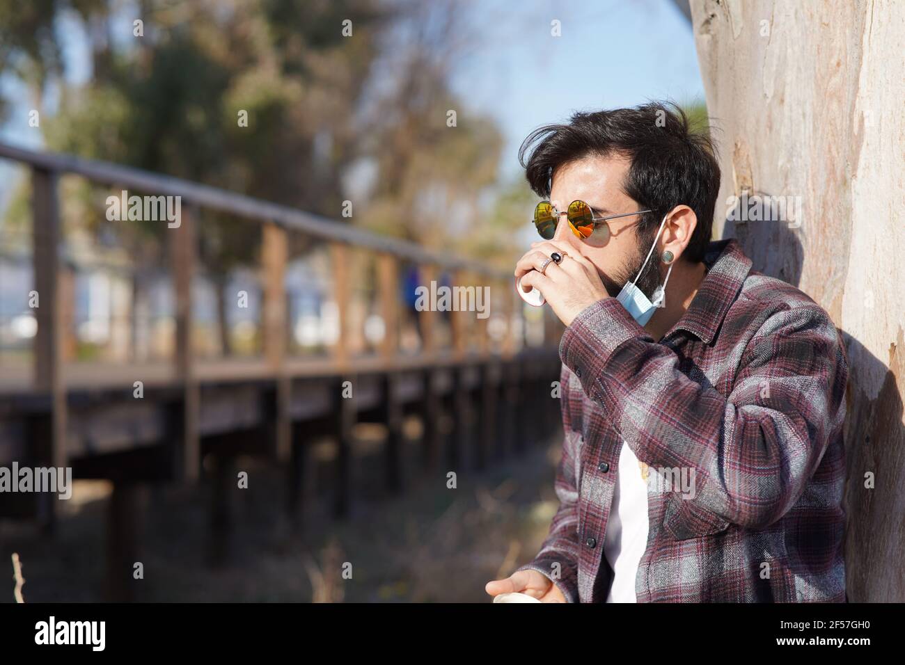 Young cool male in a street style outfit and sunglasses posing outdoors ...