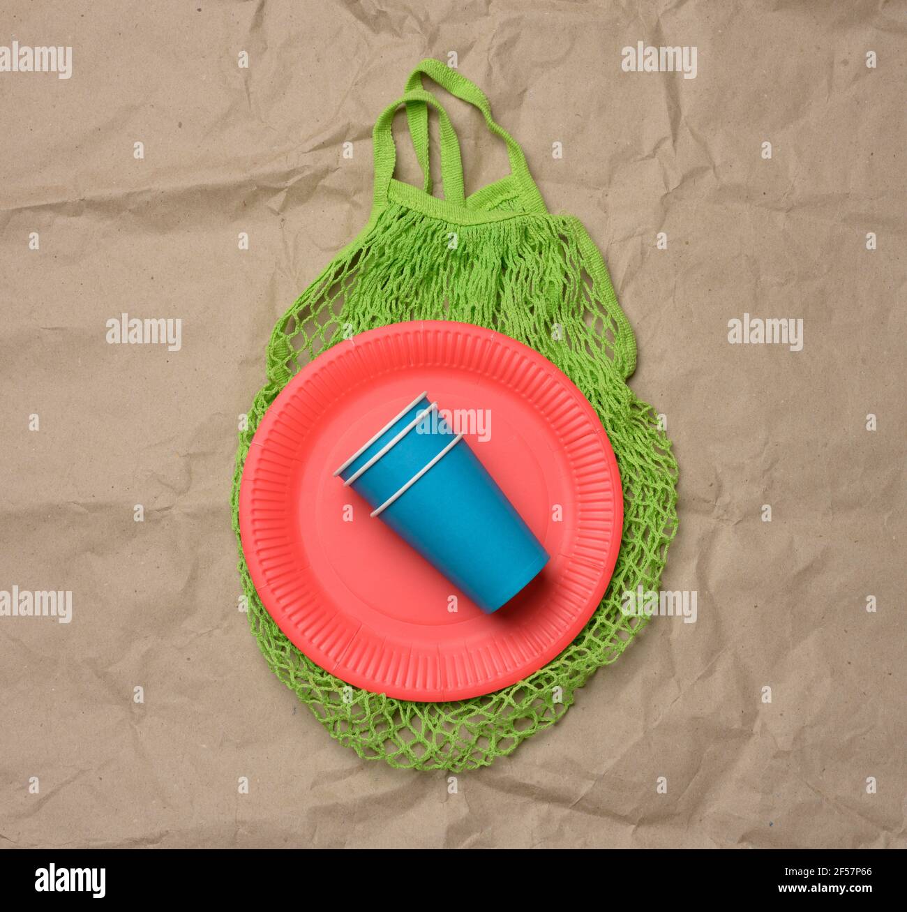 stack of blue paper cups and red round plates on a brown paper ...