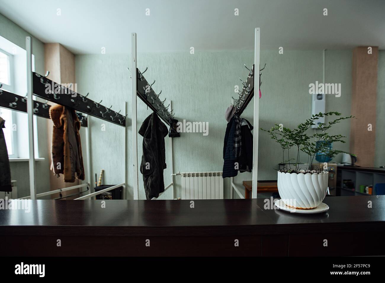 wardrobe at the hotel reception. jackets and dresses hang on hooks on a ...