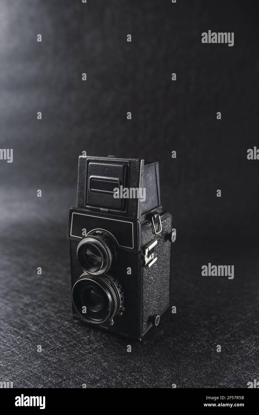 Vertical shot of a retro camera on a black background Stock Photo - Alamy