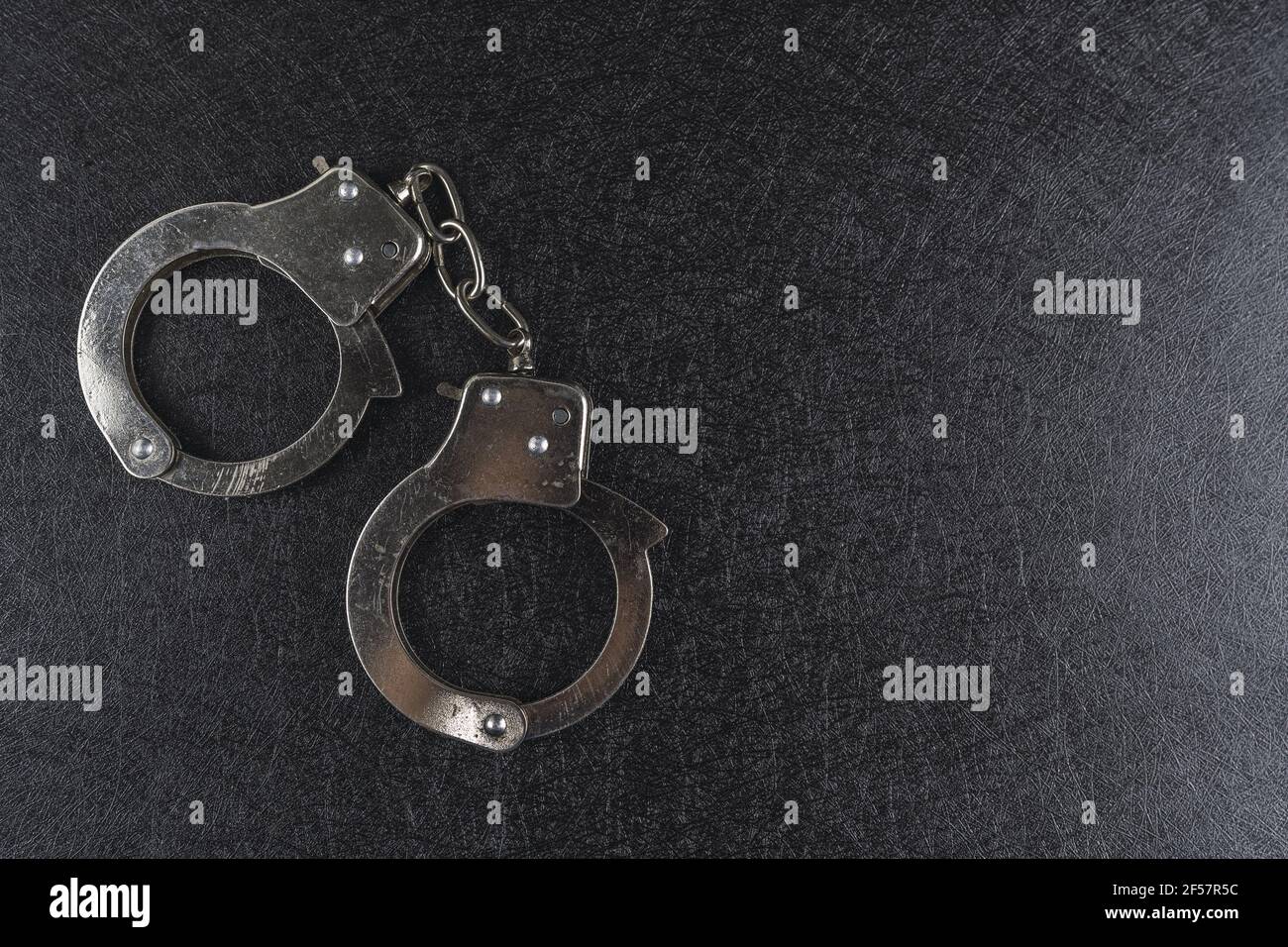 Top view shot of handcuffs isolated on black background with space for ...