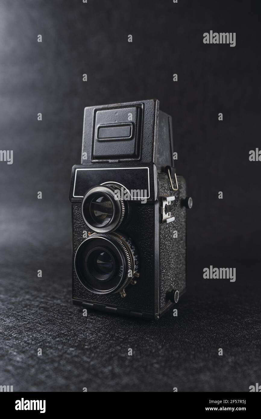 Vertical shot of a retro camera on a black background Stock Photo - Alamy