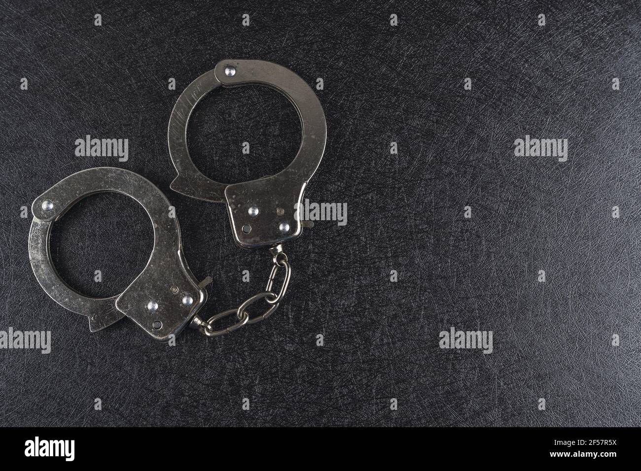 Top view shot of handcuffs isolated on black background with space for ...