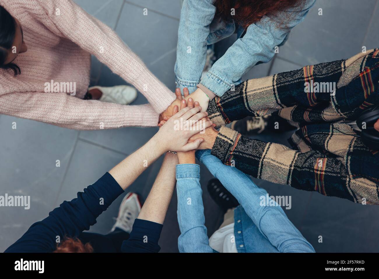 Hands stacking in college by friends. Young People putting hands ...