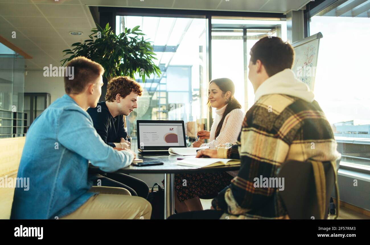 Group of students at university with laptop. Young men and women ...