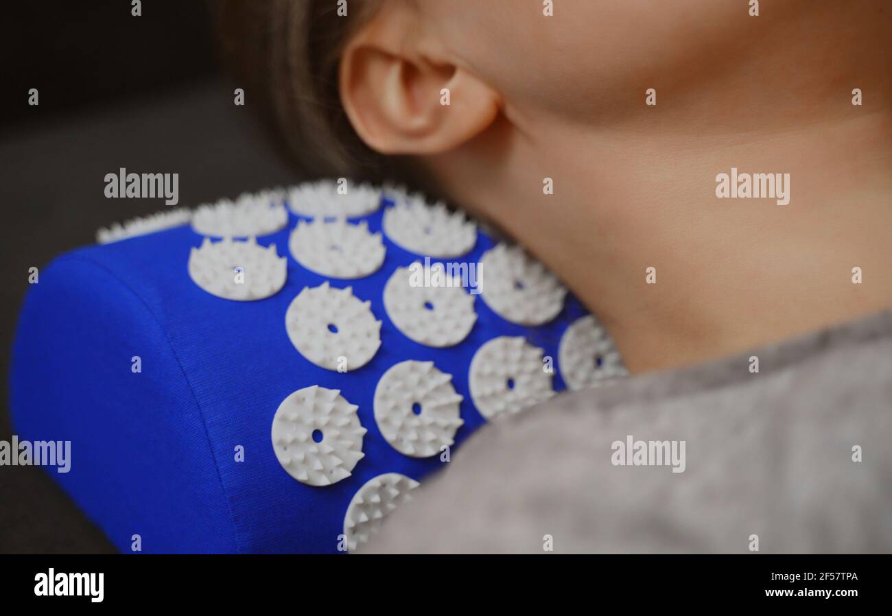 Woman is using acupuncture applicator pad for her neck Stock Photo - Alamy
