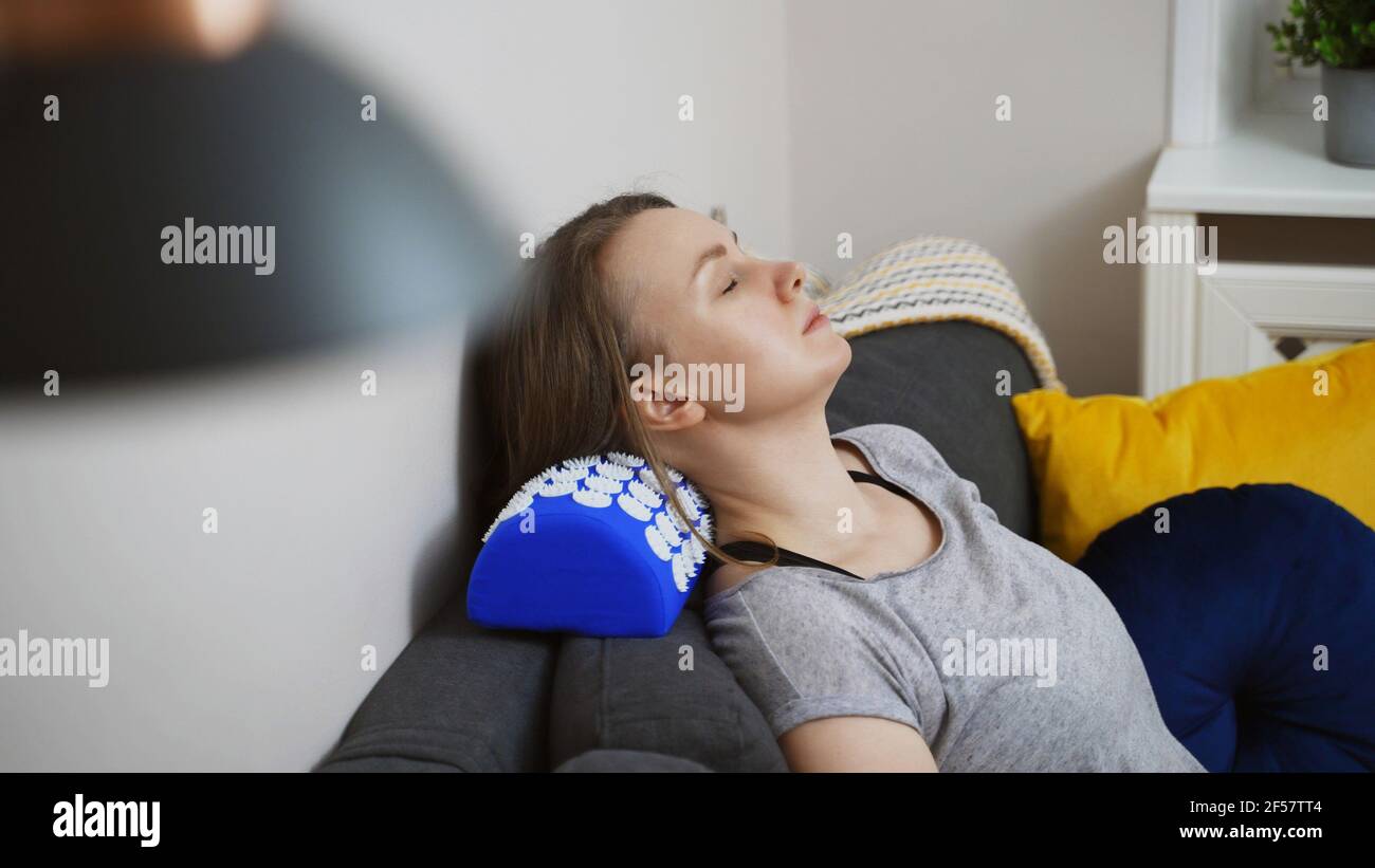 Woman is using acupuncture applicator pad for her neck Stock Photo - Alamy