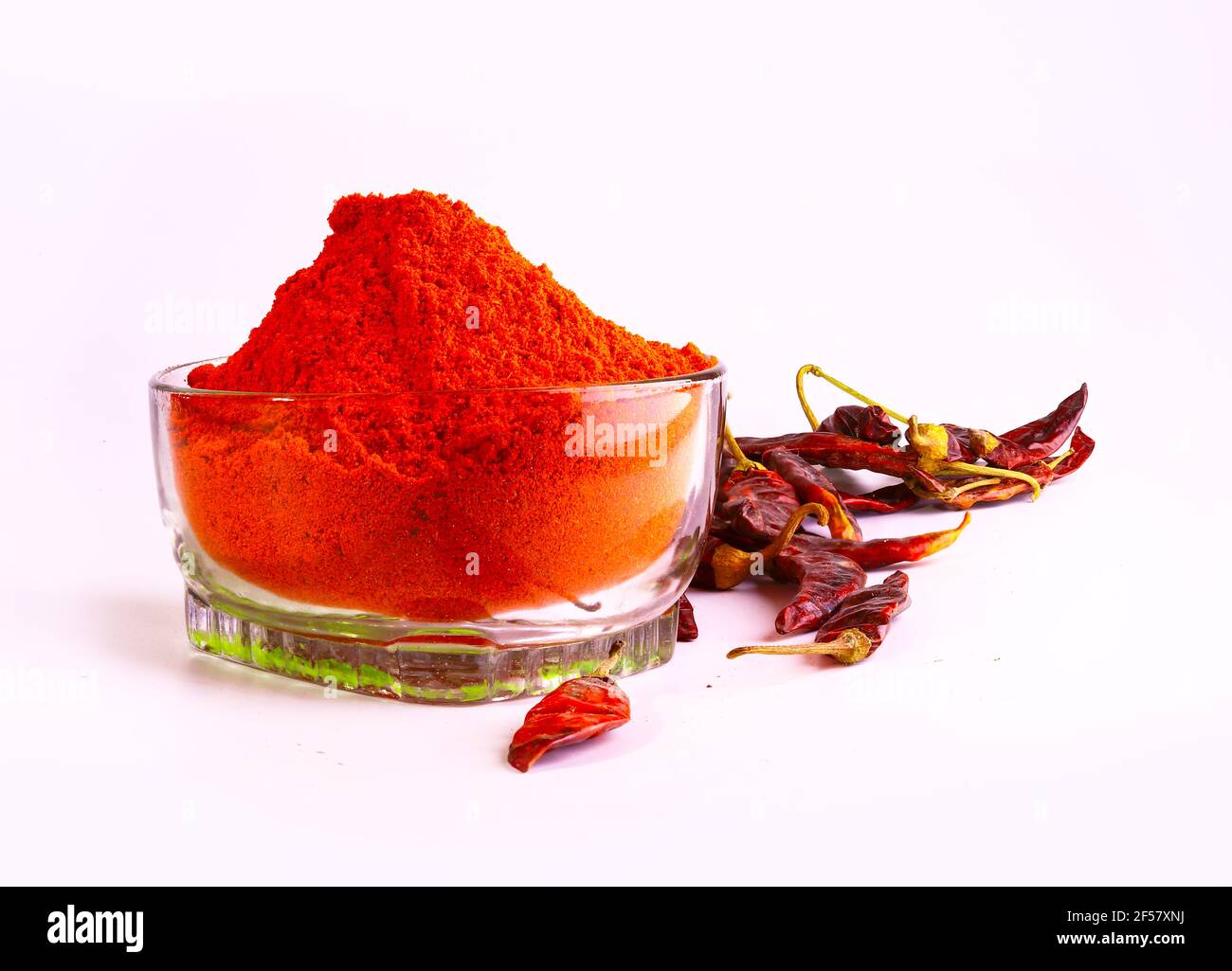 Red chilly peppers and powder of dried chilies in a bowl isolated in ...