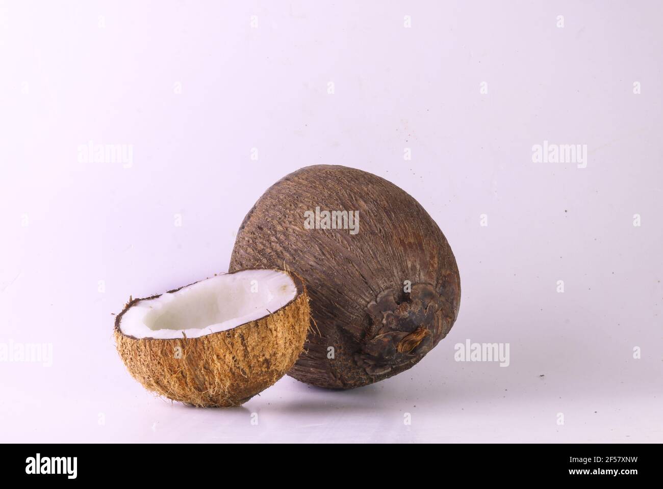 Cracked opened coconut isolated in the light background Stock Photo - Alamy