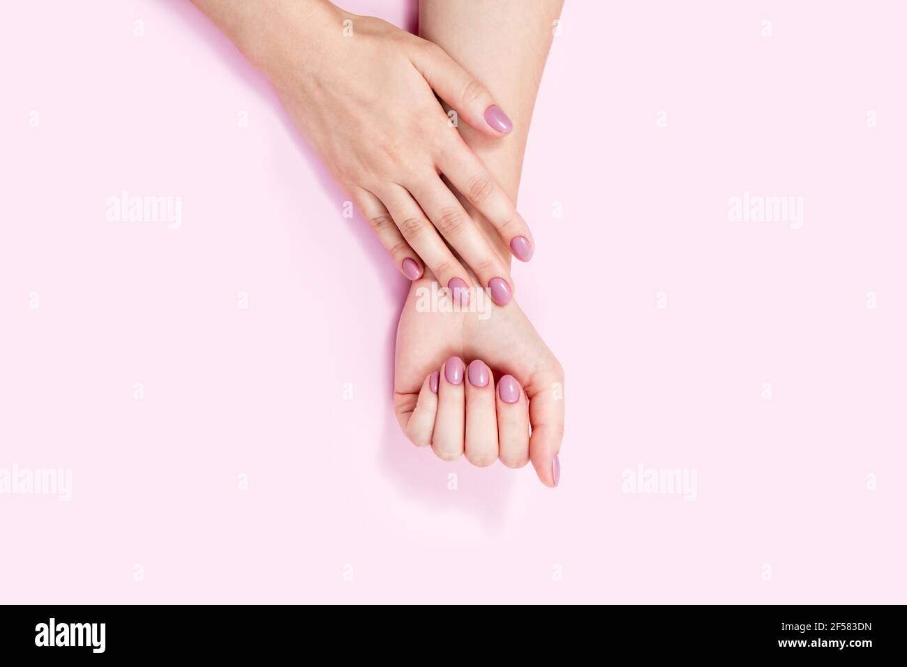 Beautiful female hands on a pink background Stock Photo - Alamy