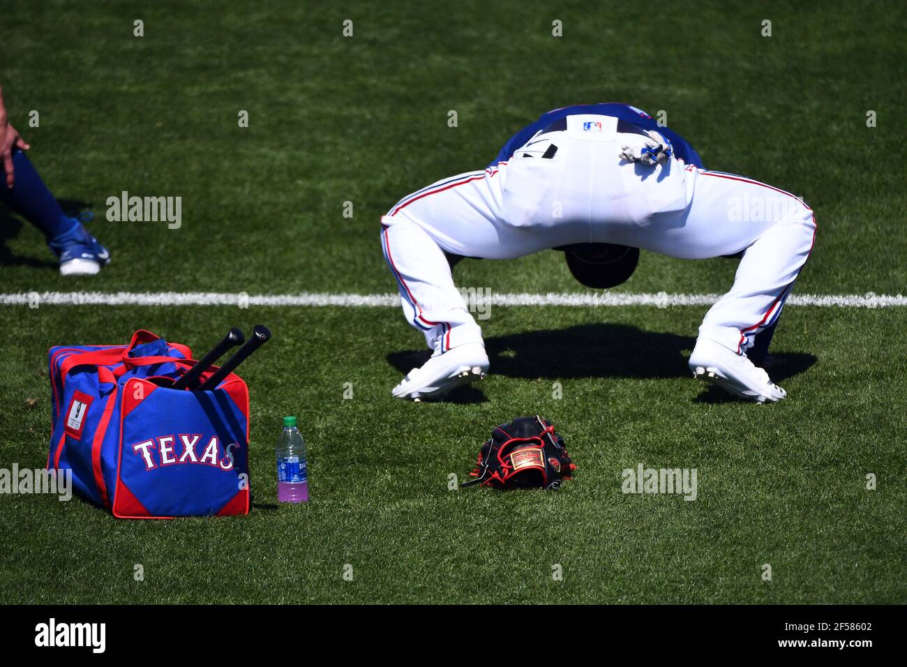 A Texas Rangers player stretches before a MLB spring training game at ...