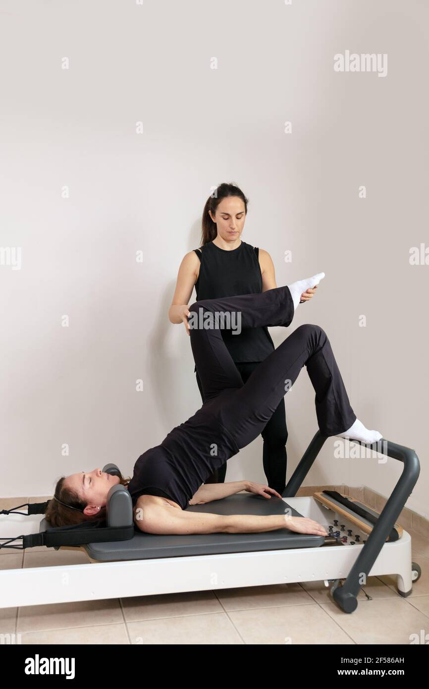 A woman practicing exercises with a pilates personal trainer Stock ...