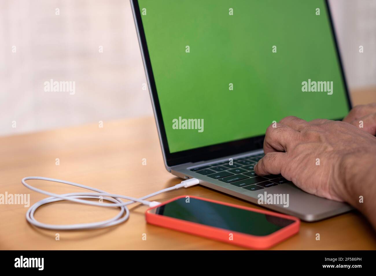 Man working from home using laptop computer connected to office by ...