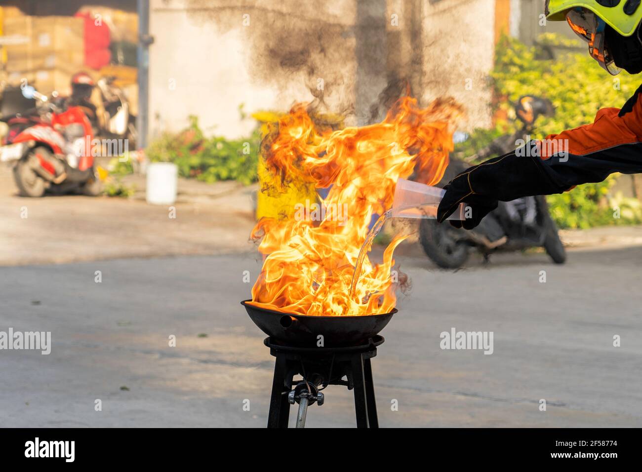 Firefighters teach or demonstrate the fire by pouring water into a very ...
