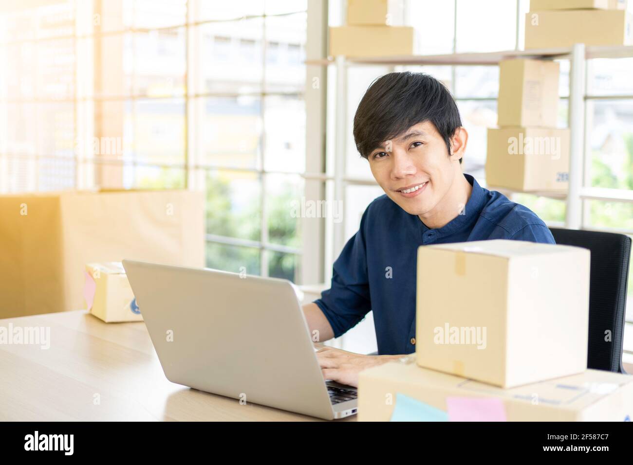 Asian man packing boxes hi-res stock photography and images - Alamy