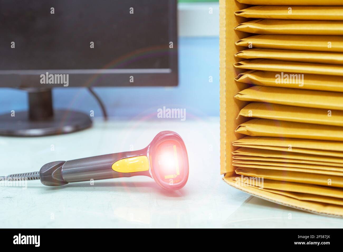 Brown paper envelopes in the box and a barcode reader on the desk wait ...