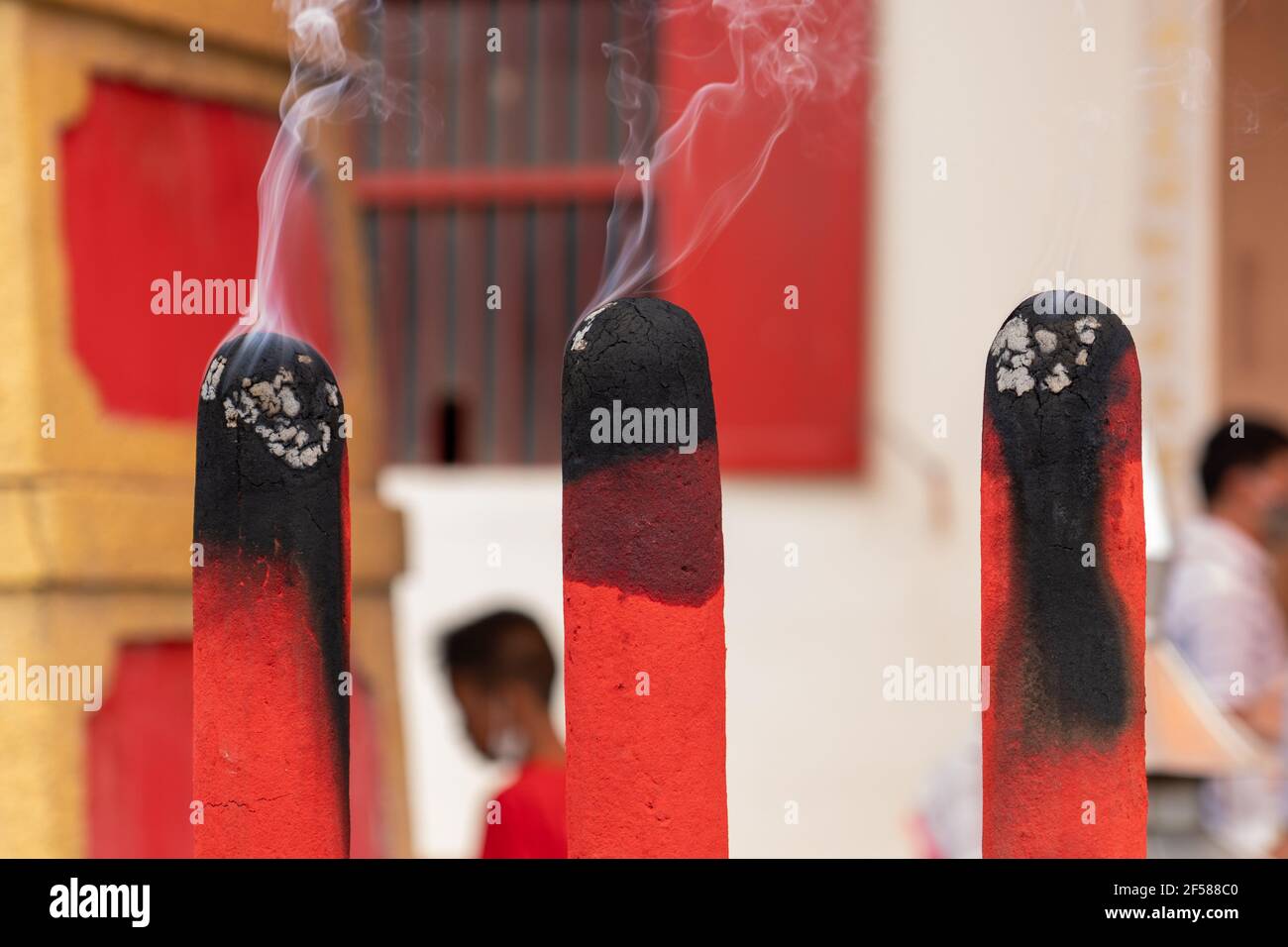 Three big red incense with smoke from people who come to light incense ...