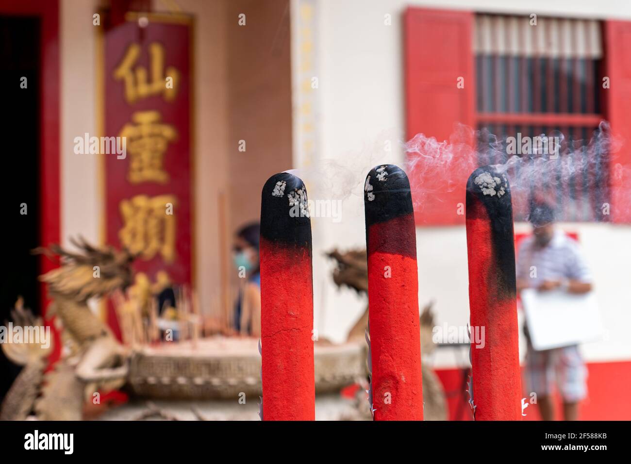 Three big red incense with smoke from people who come to light incense ...