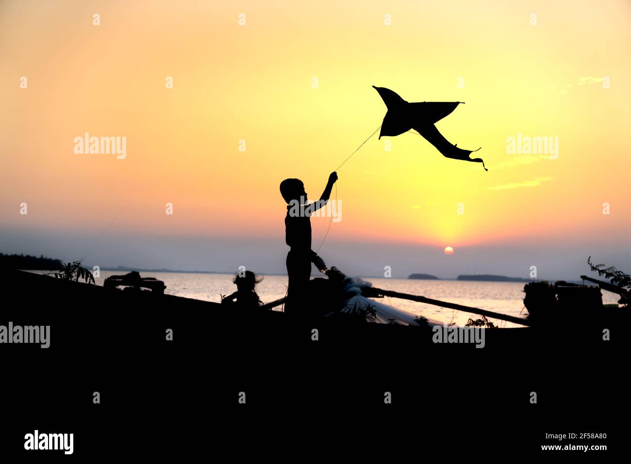 Rural children flying kites at sunset Time. Silhouette Stock Photo - Alamy