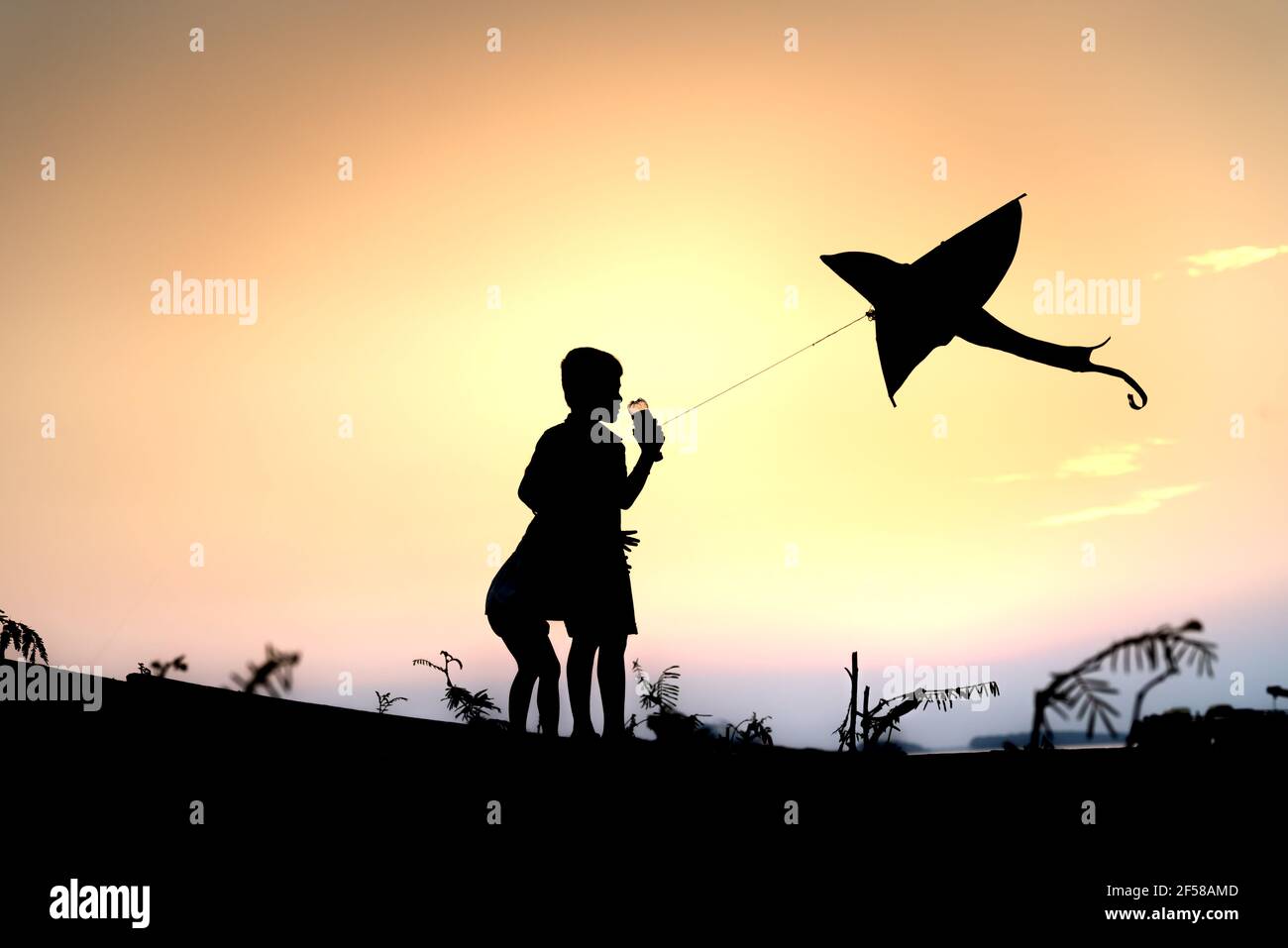 Rural children flying kites at sunset Time. Silhouette Stock Photo - Alamy
