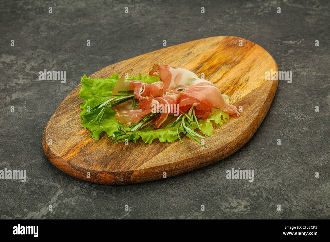 Sliced pork Jamon meat with rosemary Stock Photo - Alamy
