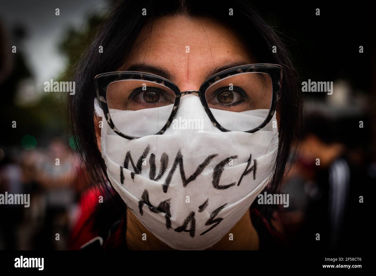 A protester wearing a face mask saying "Never again." during the ...