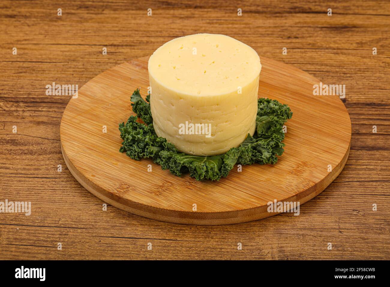 Yellow round dairy soft cheese piece Stock Photo - Alamy
