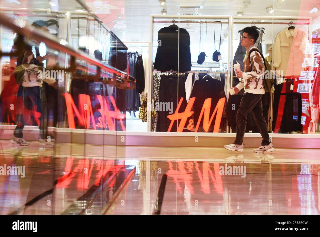 HANGZHOU, CHINA - MARCH 25, 2021 - Customers walk in front of an H&M ...