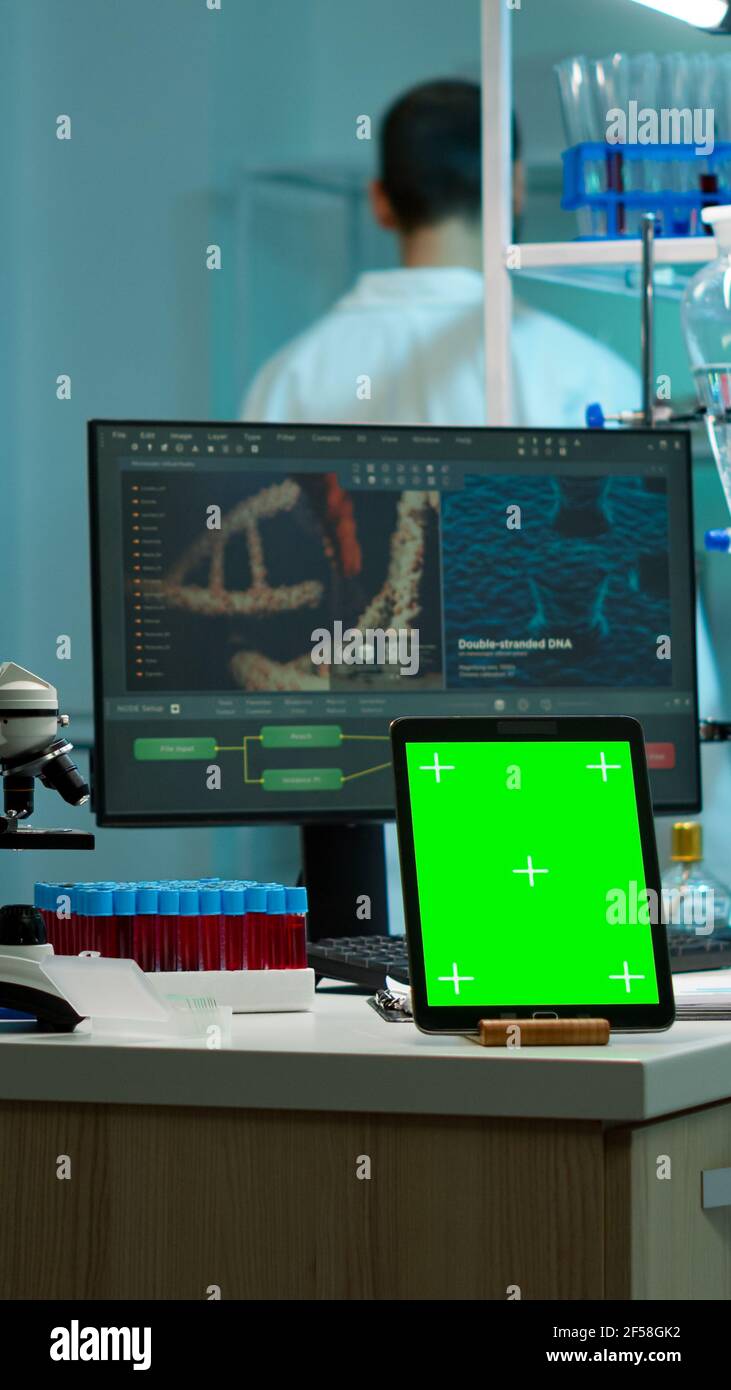 Microbiologist working on monitor in background analysing test samples ...