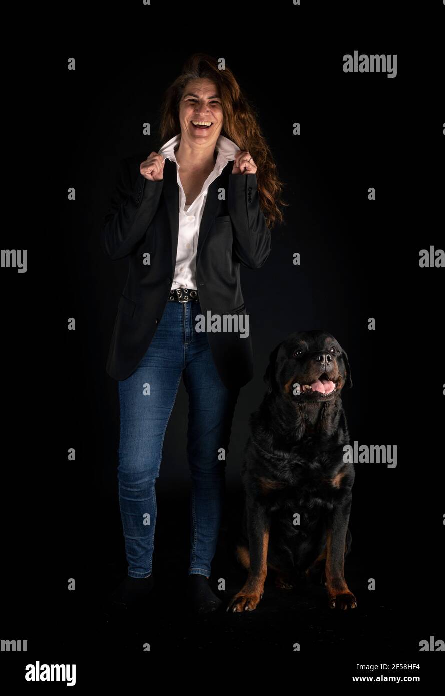 purebred rottweiler and woman in front of black background Stock Photo ...
