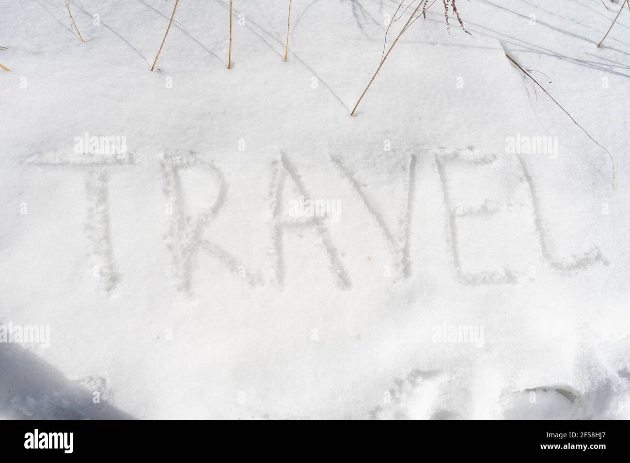 travel text written in the snow Stock Photo - Alamy