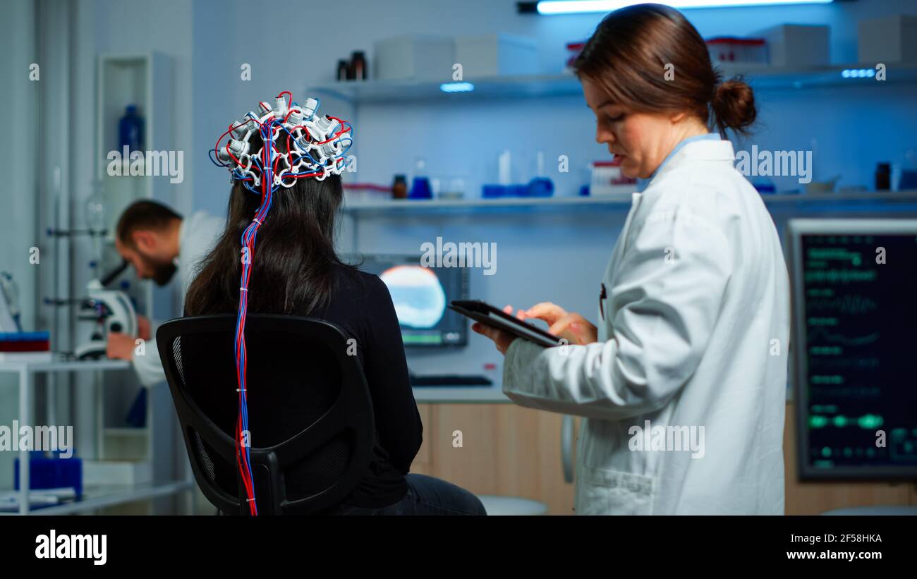Back view of woman patient wearing performant eeg headset sitting on ...
