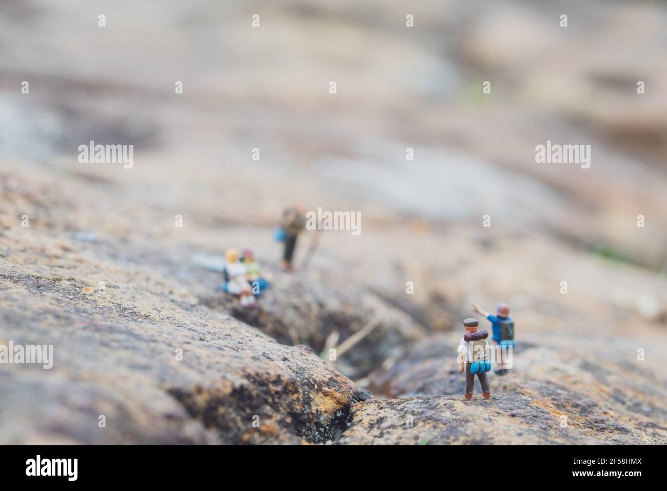 Fun concept of miniature hiker figure adventure in the rocks, outdoor ...