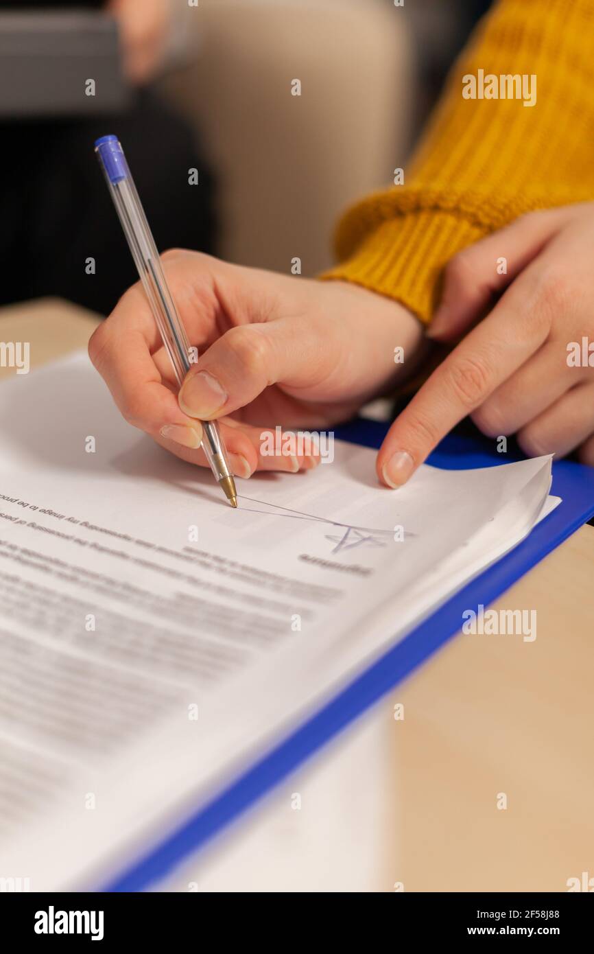 Businesswoman signing paper, partner hand puts signature on business ...