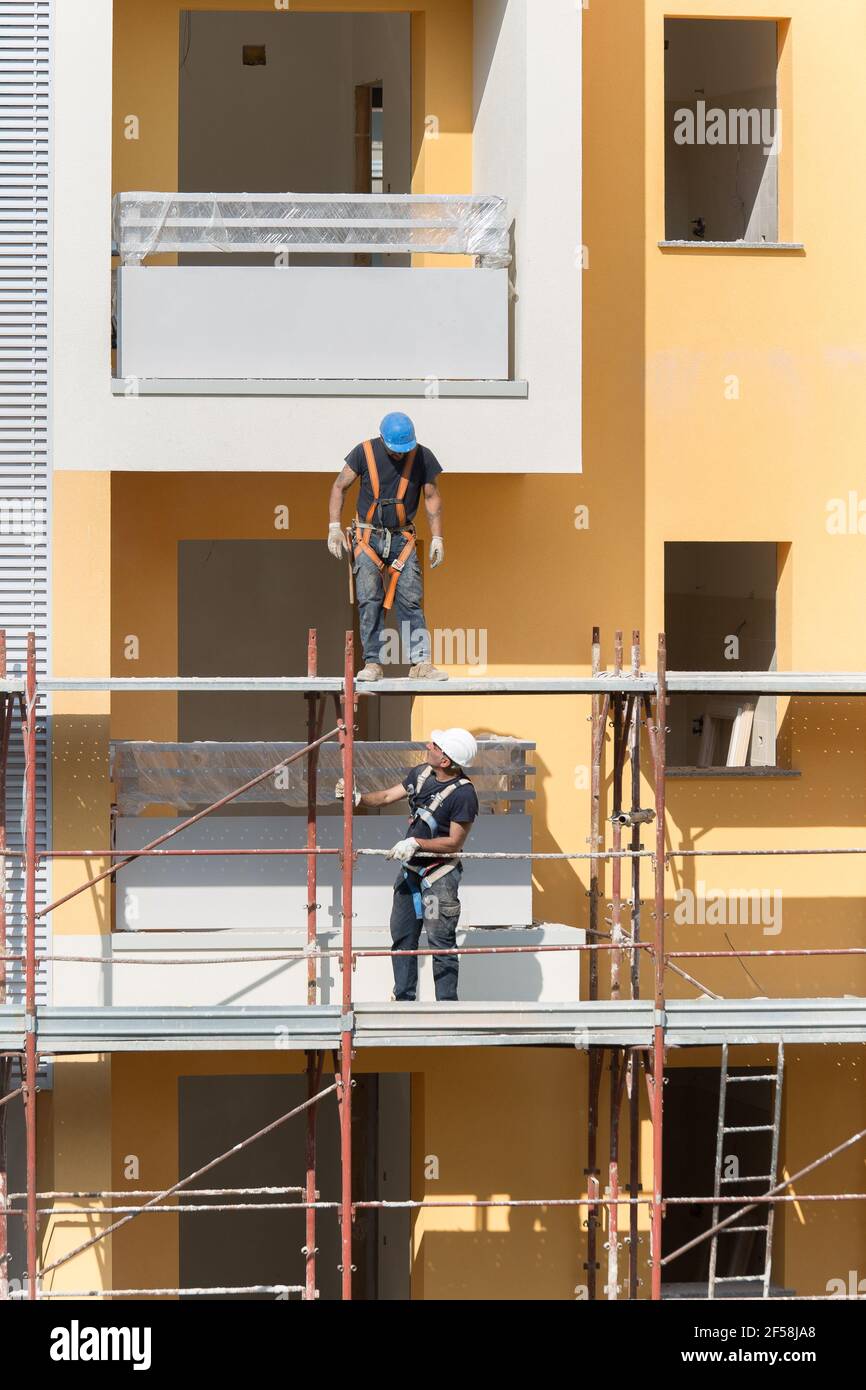 Workers at Work on a Scaffold in a Building Site for the Construction ...