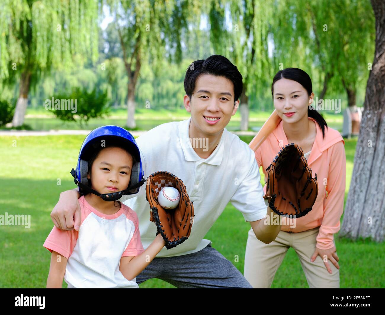 Happy family of three playing baseball in the park,smiling Stock Photo ...