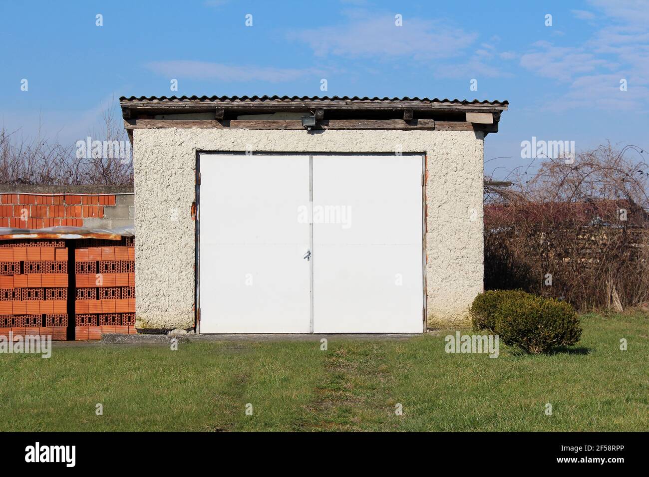 Old car garage with new white doors and preparation for new facade ...