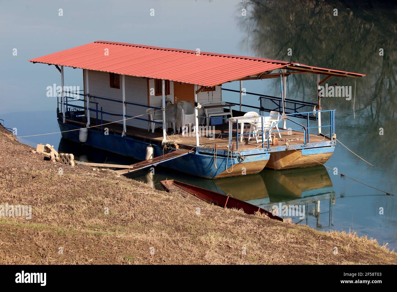 River barge converted into river boat house with improvised homemade ...
