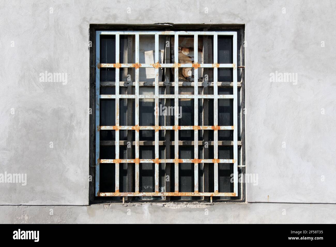 Rusted metal bars protection covering old broken window with safety ...