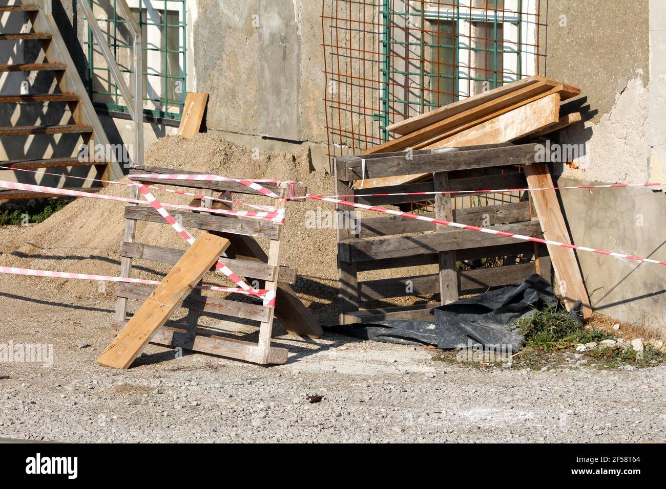 Sand pile and wooden pallets mixed with wooden boards and various other ...