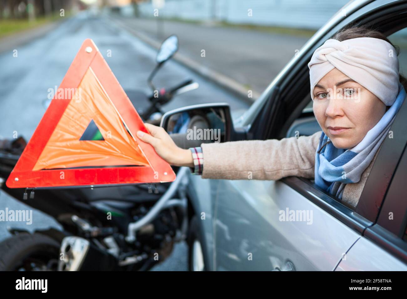 Woman a driver showing triangle emergency sign while sitting in a car ...