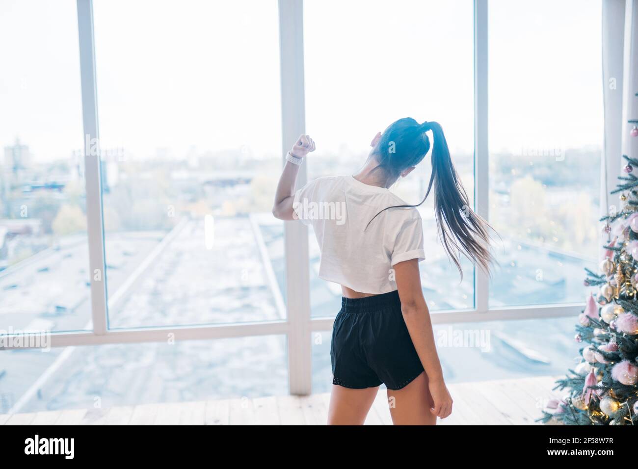 Beautiful girl in sportswear is leaning against window Stock Photo - Alamy