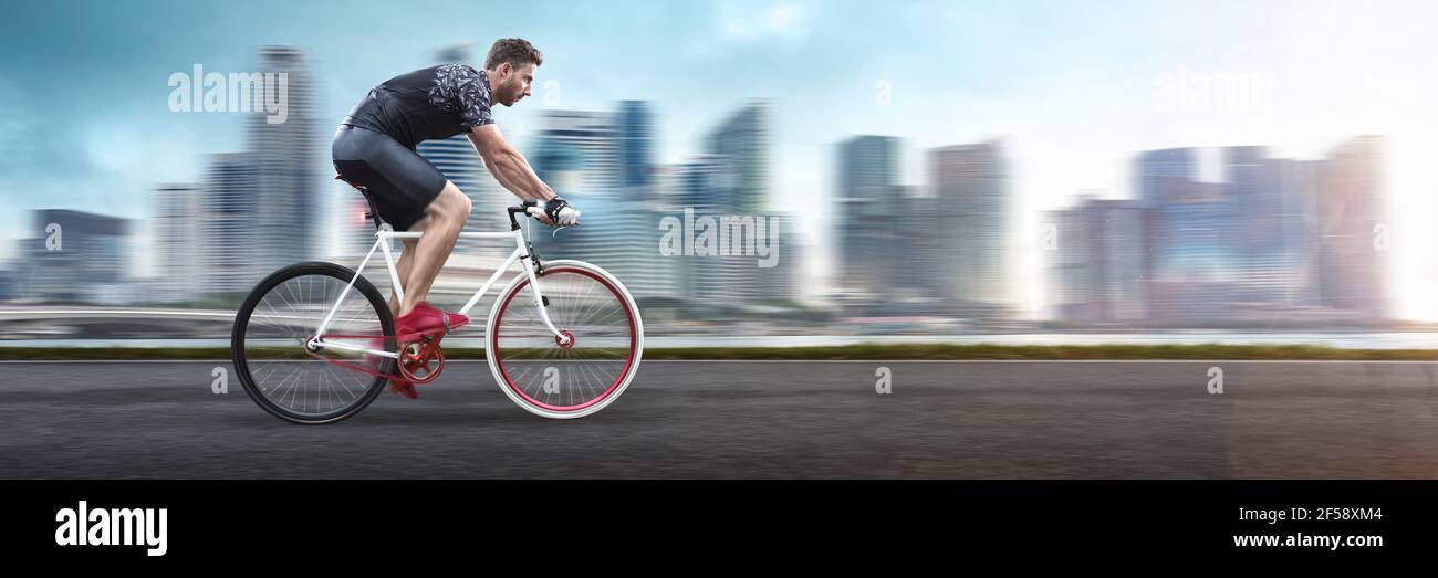 Fast riding cyclist in front of a city skyline Stock Photo - Alamy