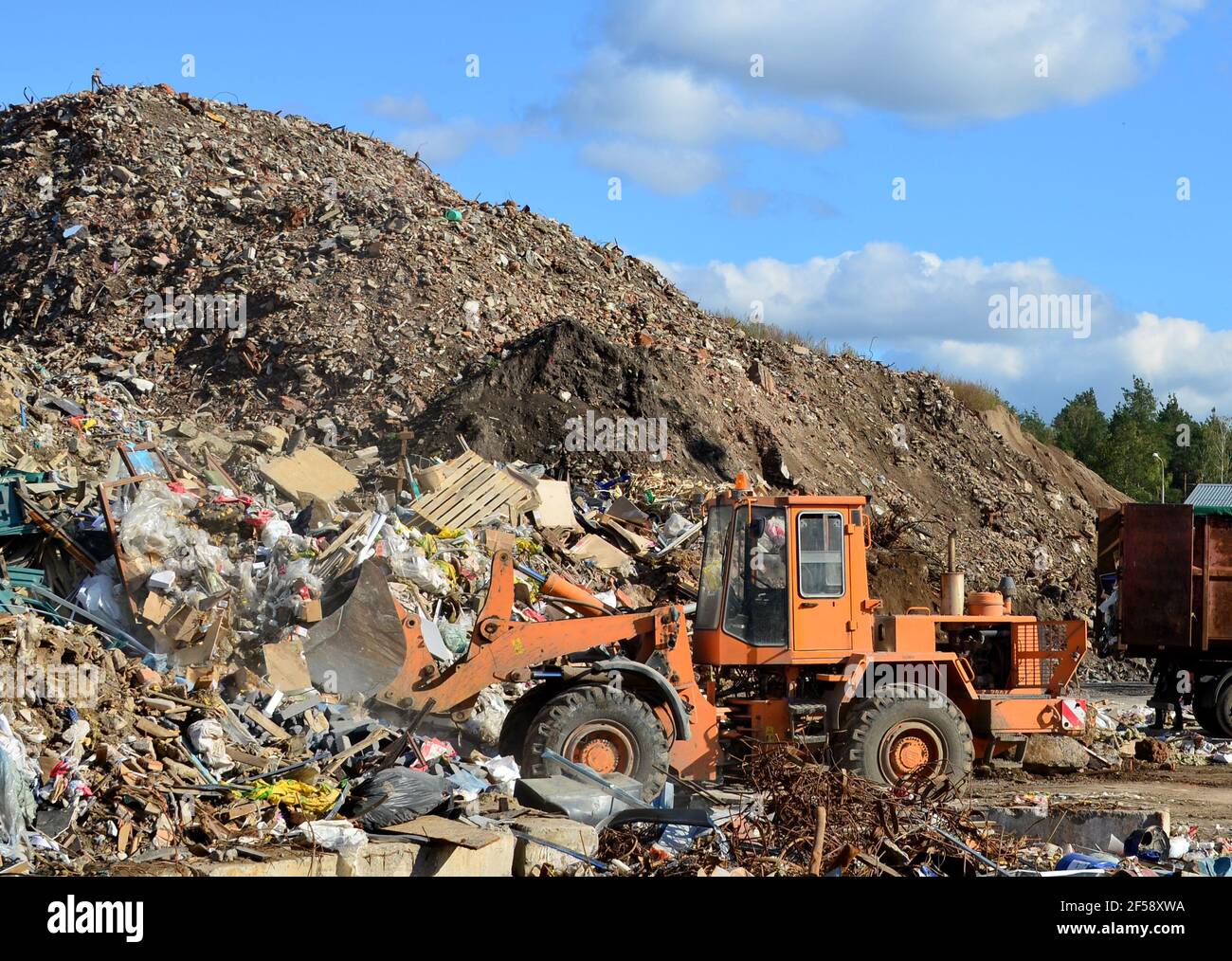 Front-end loader works in a landfill for the disposal of construction ...