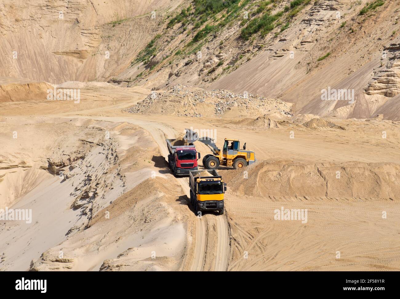 Wheel front-end loader loading sand into heavy dump truck at the ...